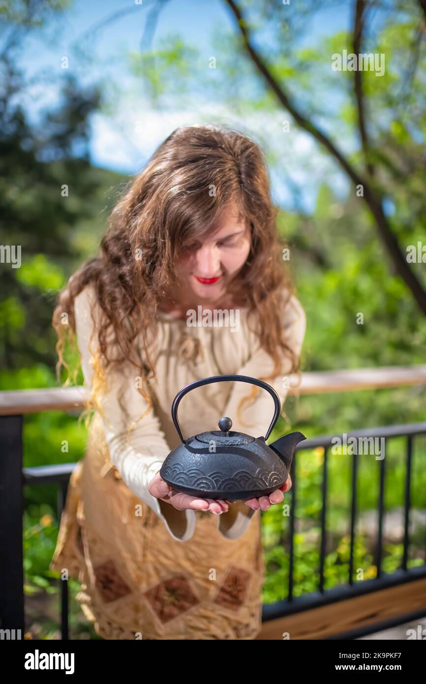 Young woman offering Japanese green tea from traditional teapot in ...