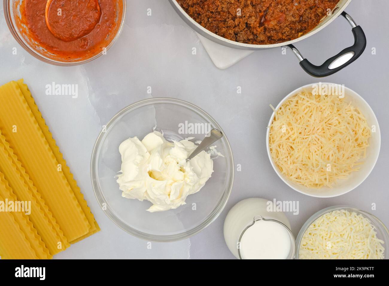 Raw lasagna noodles, ground beef on frying pan, marinara, cream cheese ...