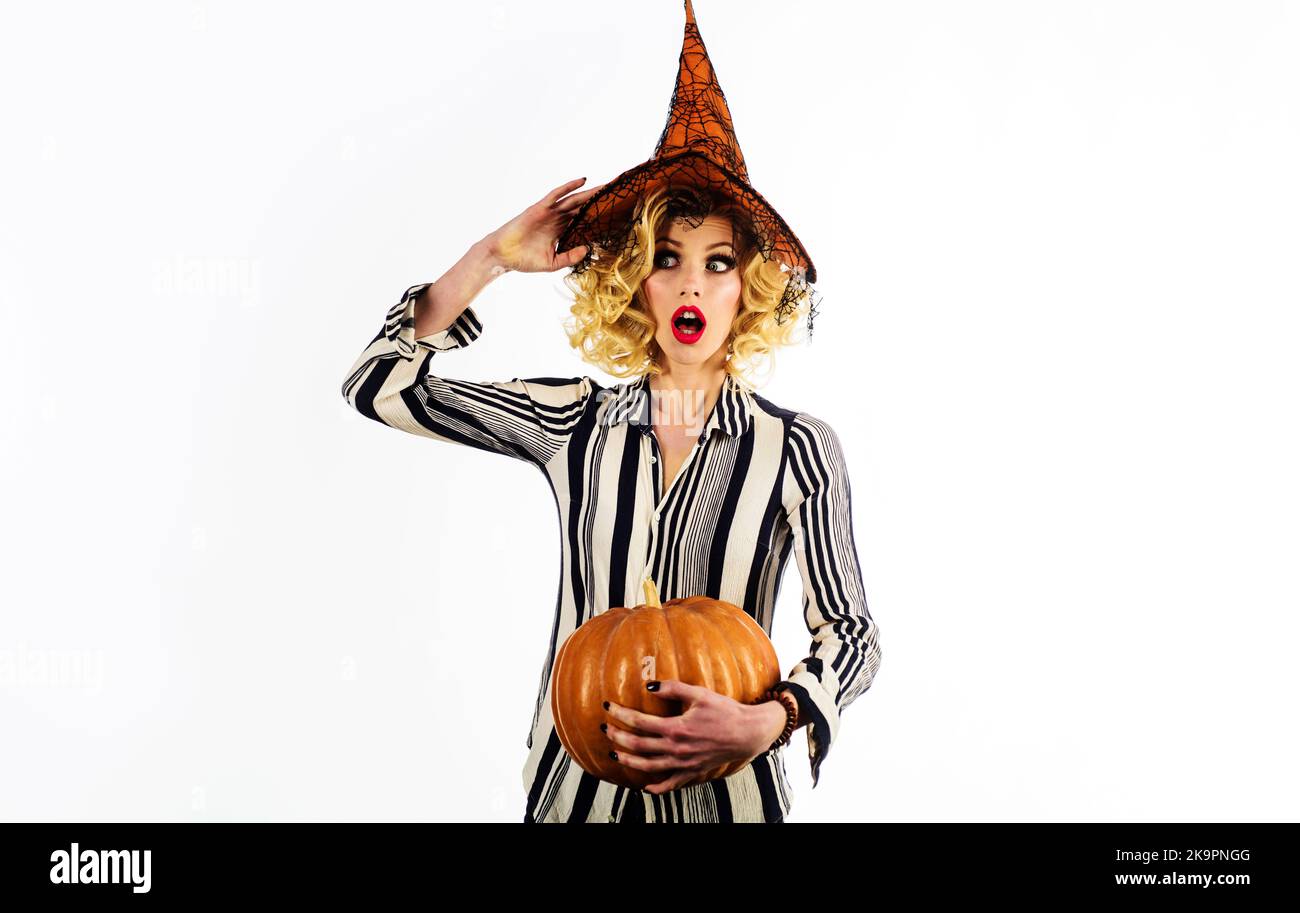 Halloween surprised witch with magic pumpkin. Beautiful woman in ...