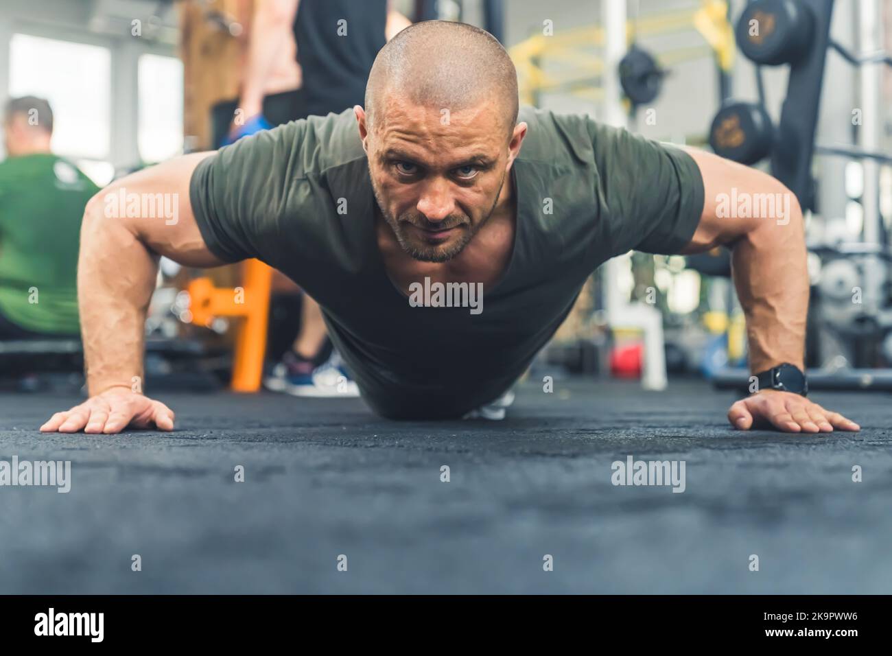 Indoor shot from floor perspective showing focused muscular bald ...