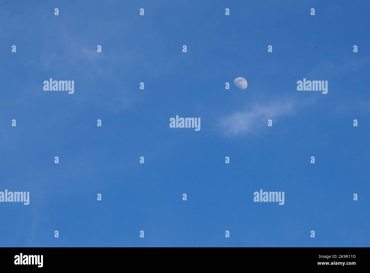 First quarter crescent moon on blue clear sky with soft fine white ...