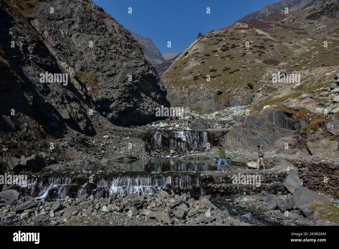 Visitors explore the waterfall at the Pir Panjal Pass, also called Peer ...