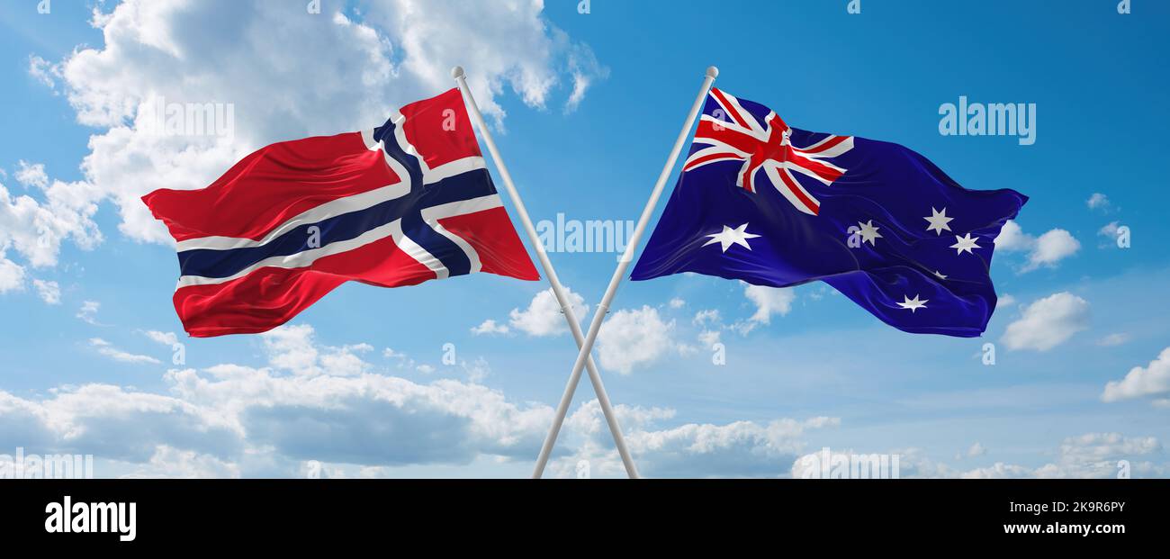 two crossed flags Australia and Norway waving in wind at cloudy sky ...