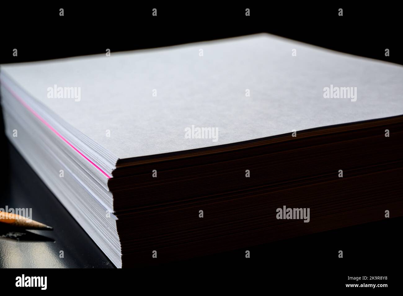 Selective focus on a single colored sheet in a stack of plain white paper Stock Photo - Alamy