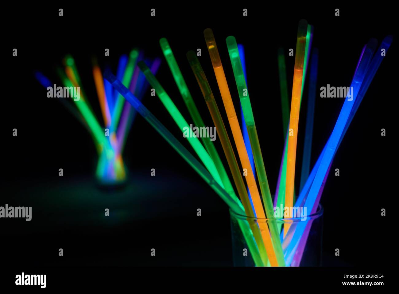 arrangement of multi-colored glow sticks against a black background ...