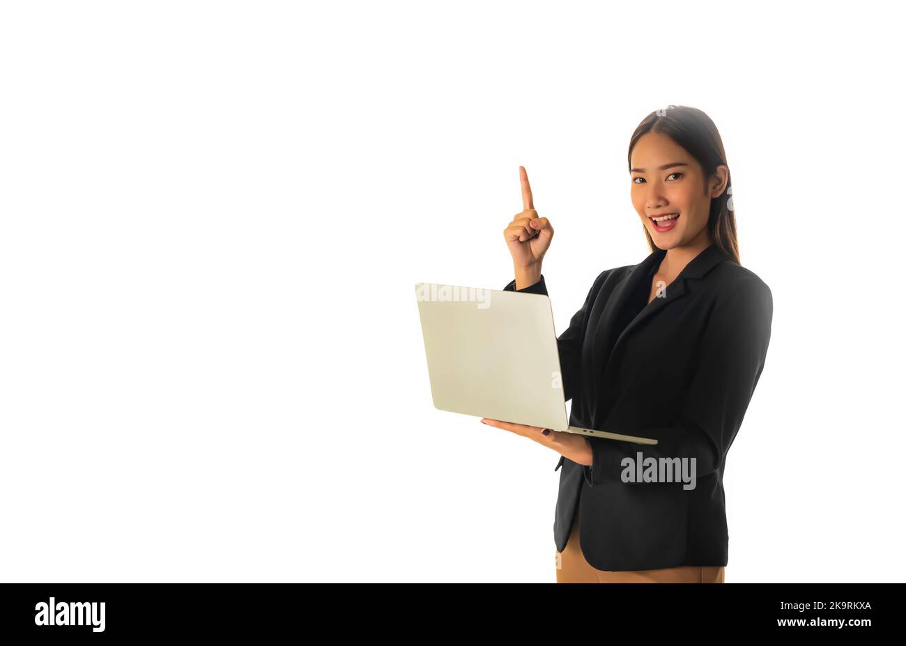 Young Asian business woman holding laptop computer and pointing hand up ...