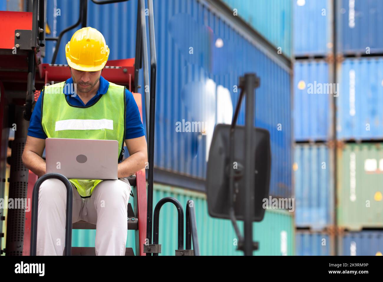 Young man working with computer at logistic import and export terminal ...