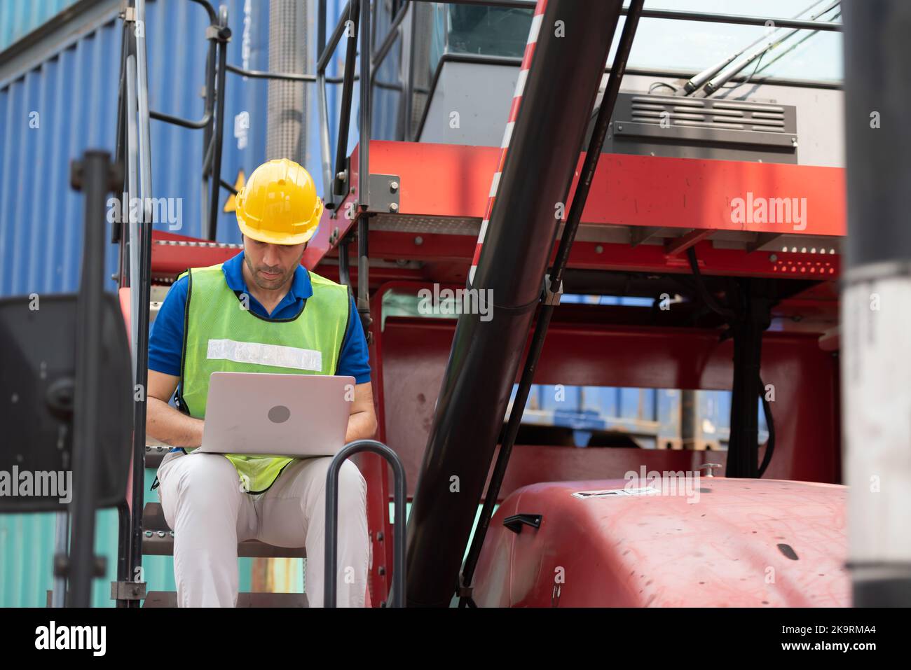 Young man working with computer at logistic import and export terminal ...