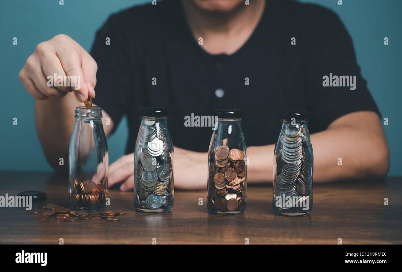 Businessman putting coin in to jar, saving, charity, family finance ...