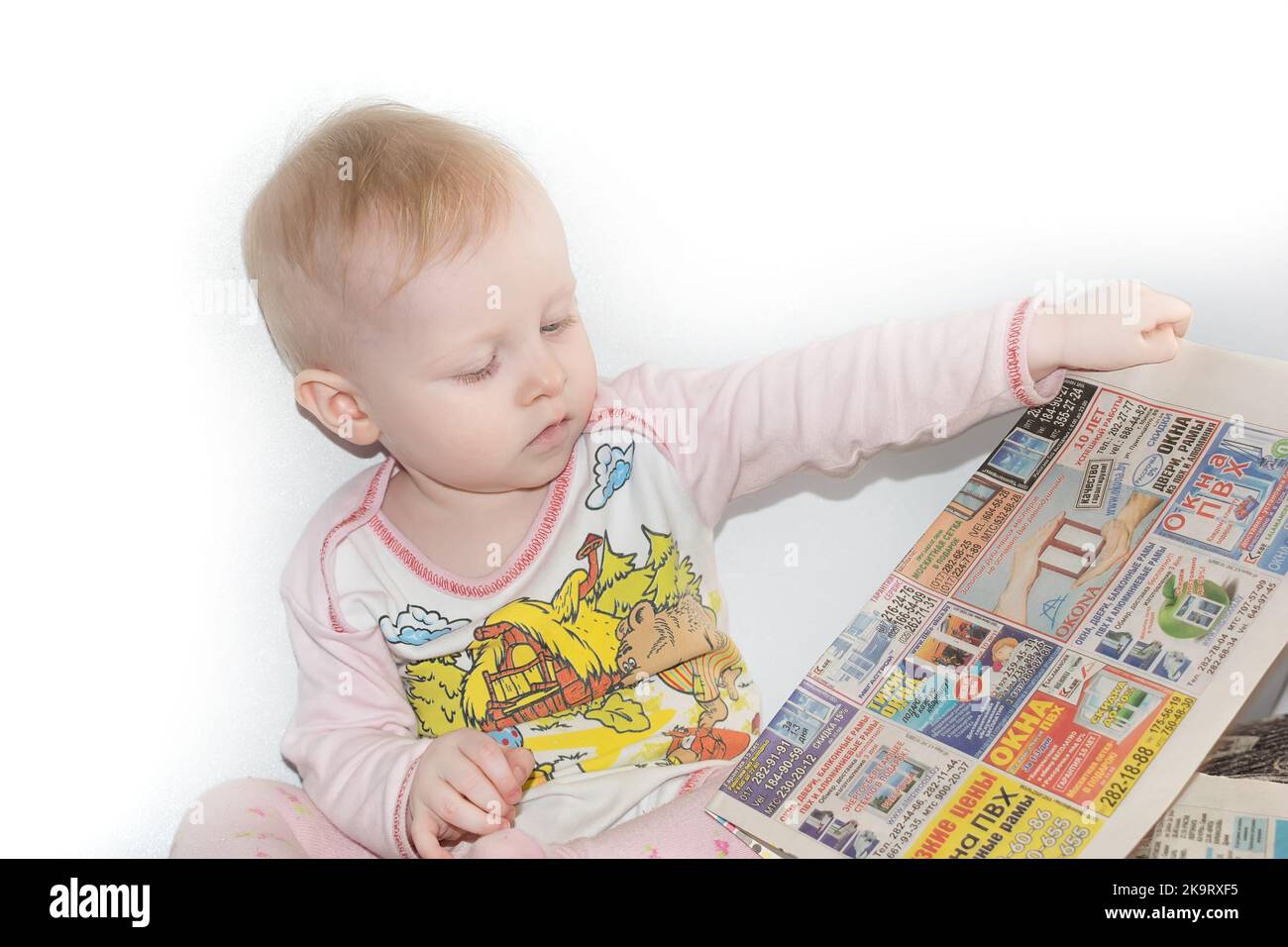 little child holding a newspaper on a white background Stock Photo - Alamy