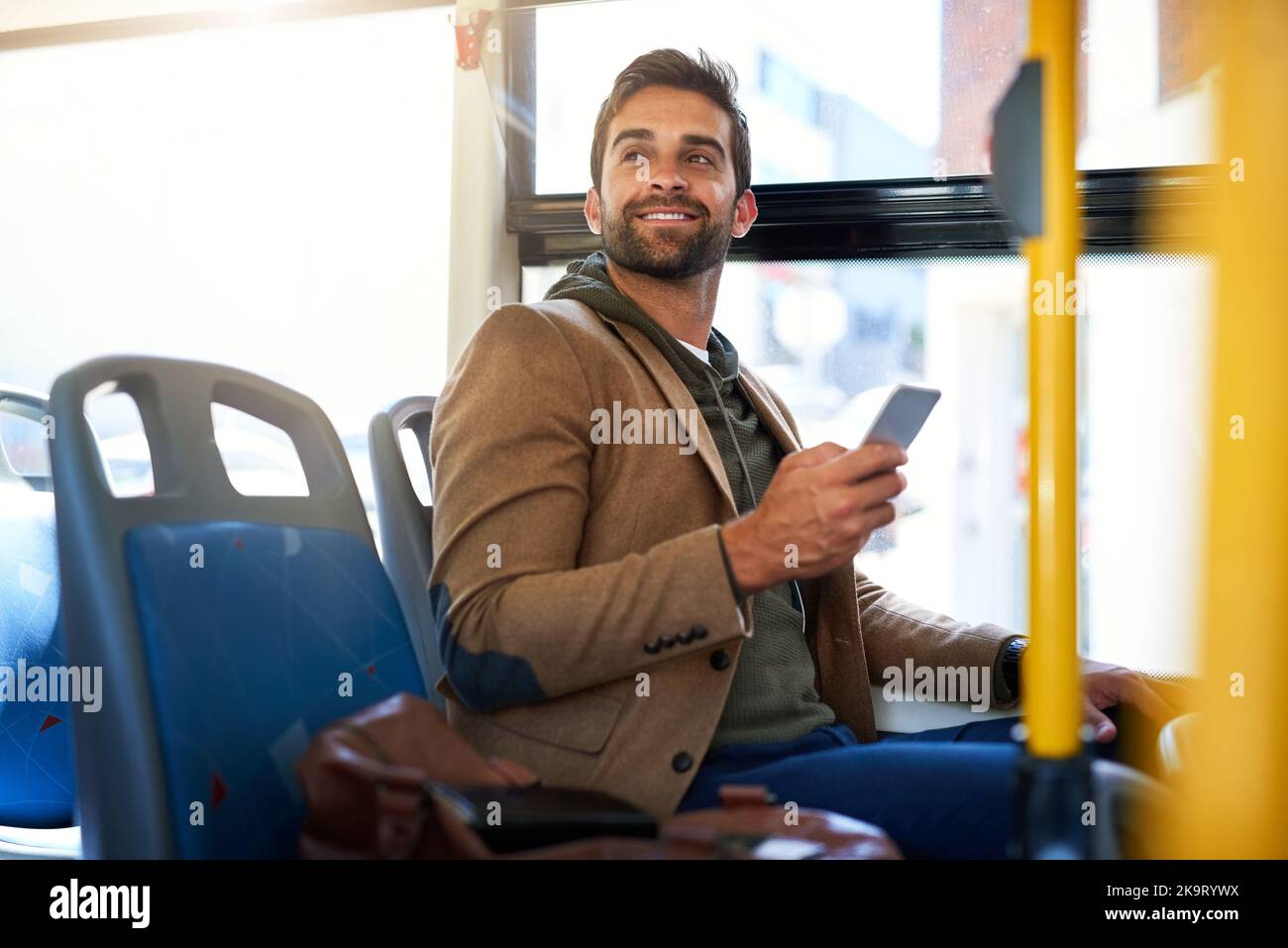 Looks like my stop. a handsome young man sending a text message during ...