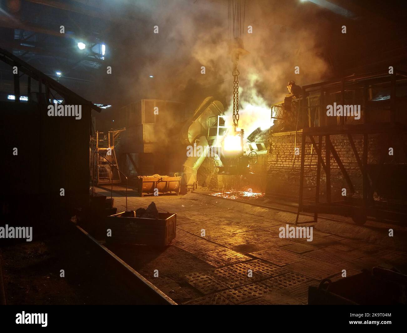 in a foundry, molten metal is poured from a furnace into a ladle Stock ...