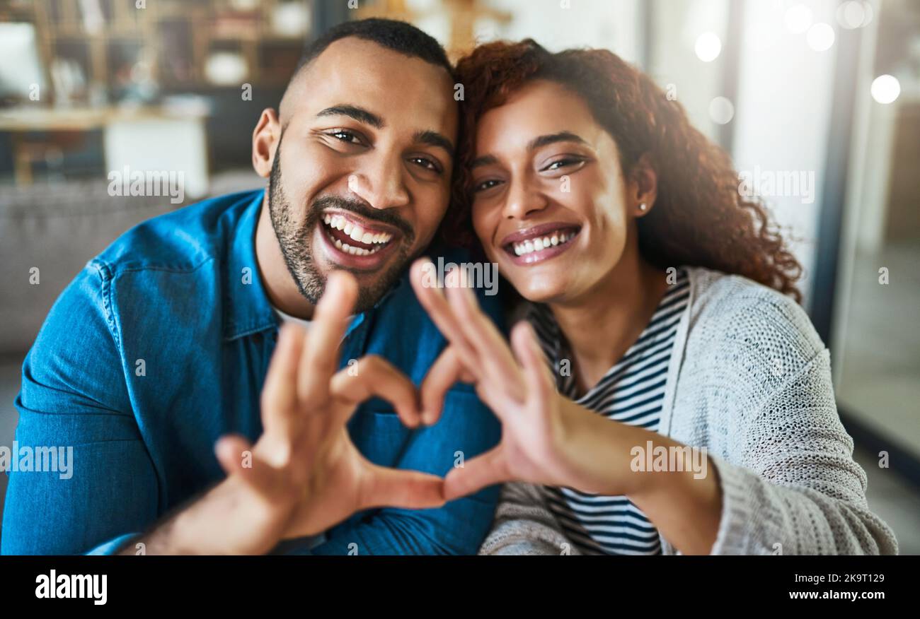 Love makes everything better. a young couple making a heart gesture ...