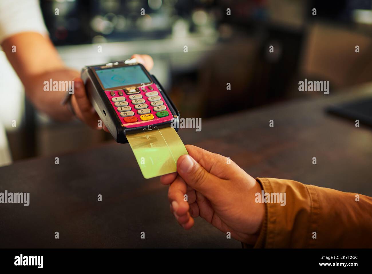 Heres your card sir. Closeup of an unrecognizable person paying their bill with a card machine ...