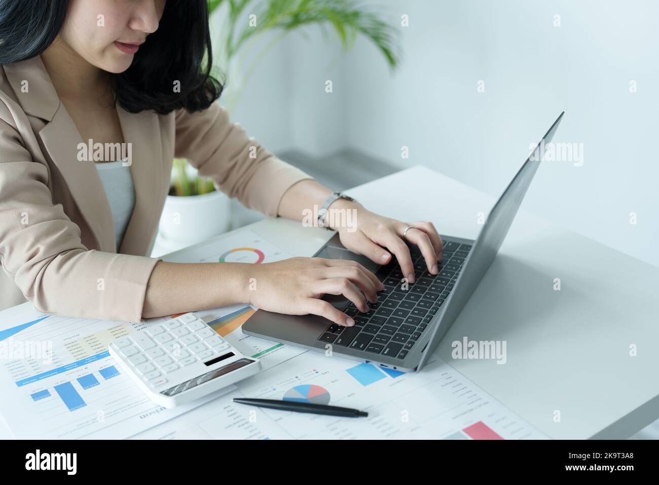 Portrait of a thoughtful Asian businesswoman looking at financial ...