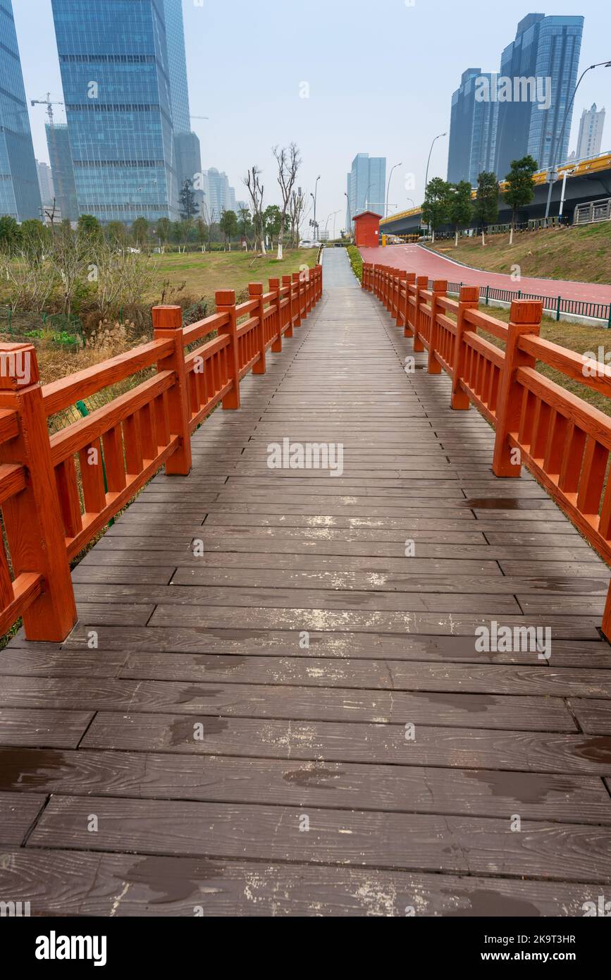 Wooden bridge over little river in city park Stock Photo - Alamy