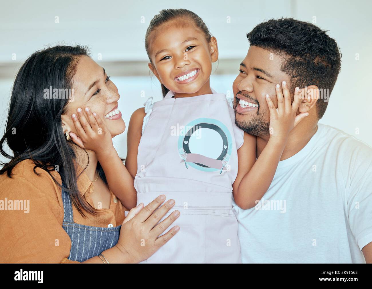 Family, parents with child, hug and apron for cooking or baking at ...