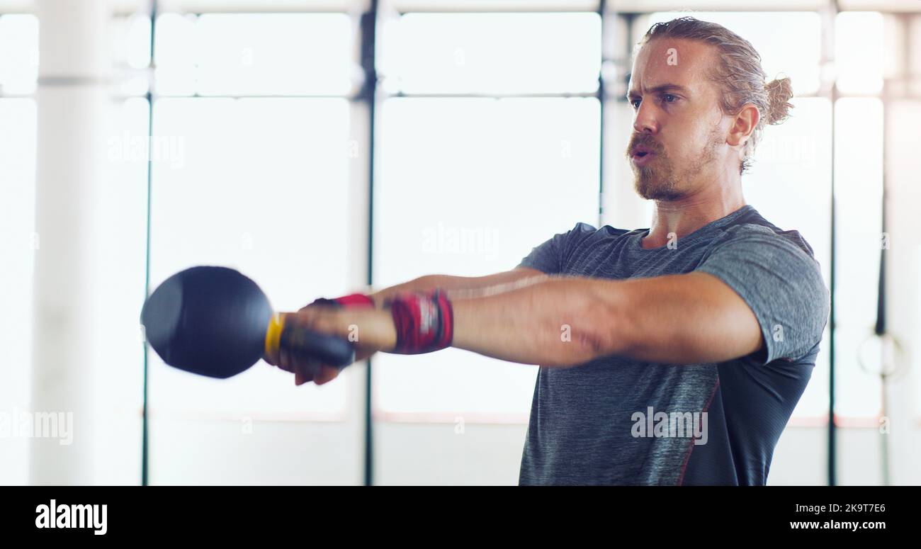 Whether in life or gym, go hard. a young man working out with kettle ...