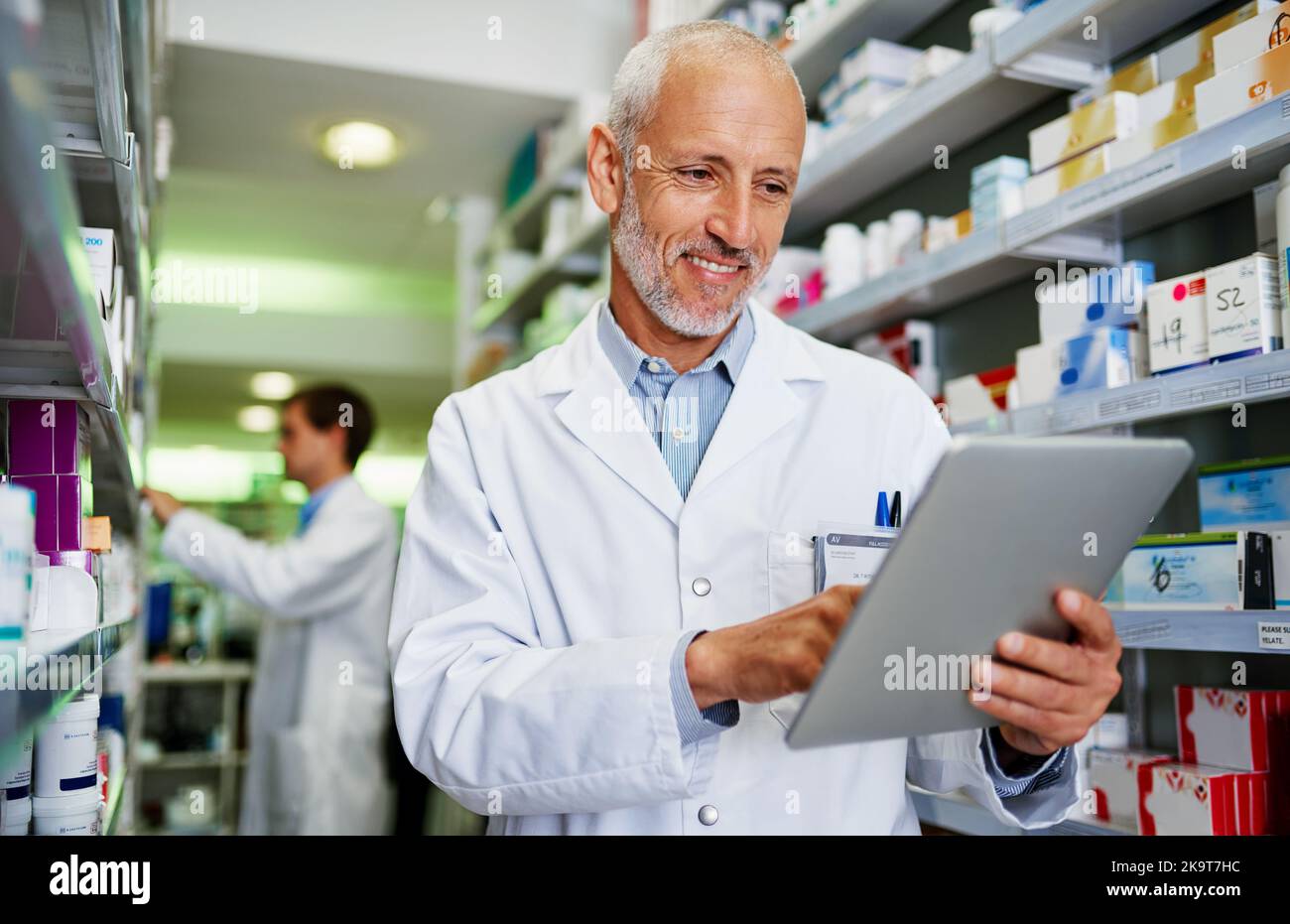 Smart pharmacists use smart technology. a mature pharmacist using a ...