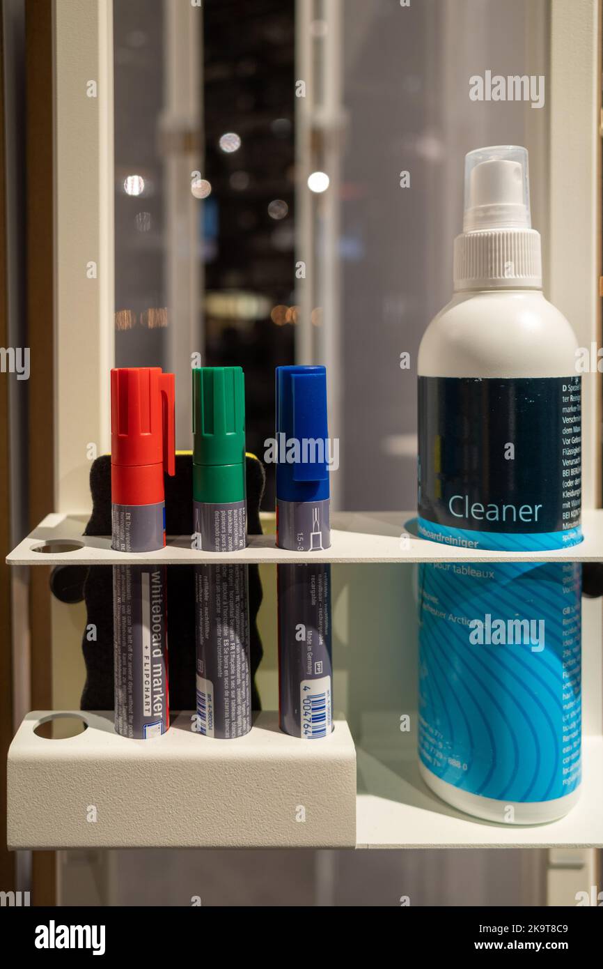 next to three board markers in different colors is a bottle with ...