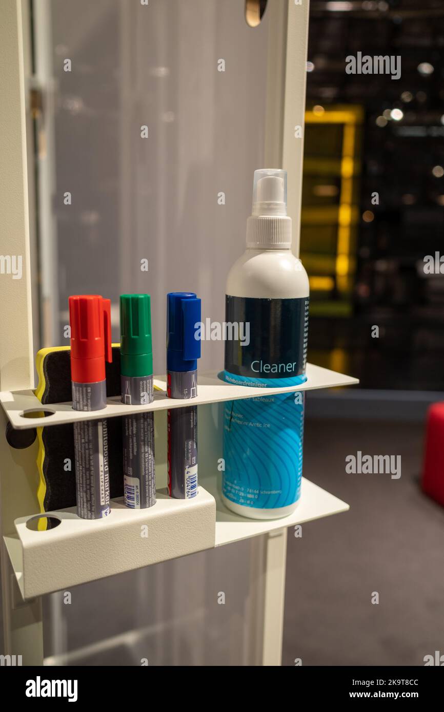 next to three board markers in different colors is a bottle with ...