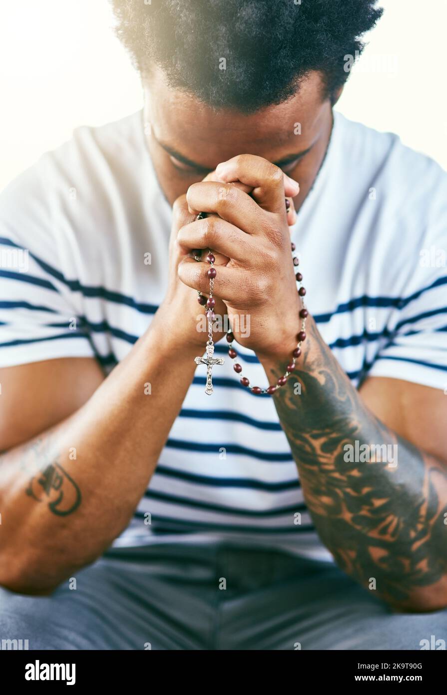 Praying man holding a rosary hi-res stock photography and images - Alamy
