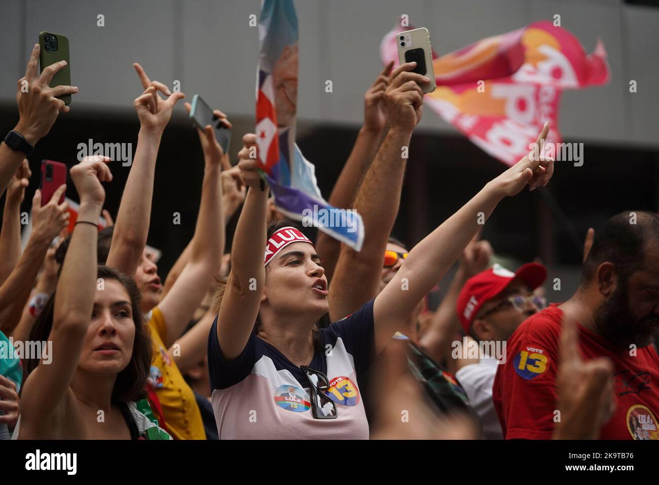 29 October 2022, Brazil, São Paulo: Lula's supporters form with their hands the gesture L, meant ...