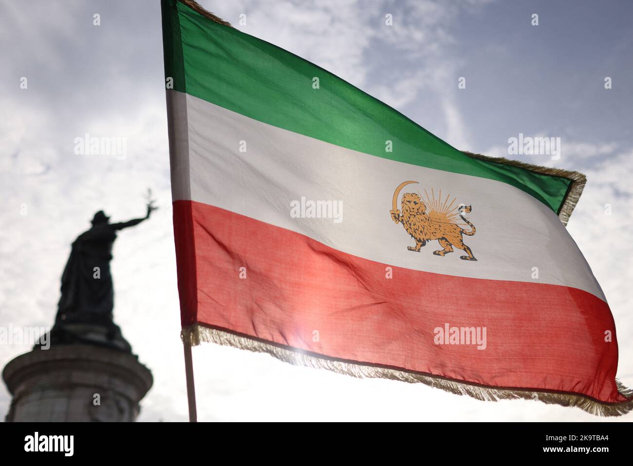 An Iran's pre-Islamic revolution flag flies near the statue of Marianne ...