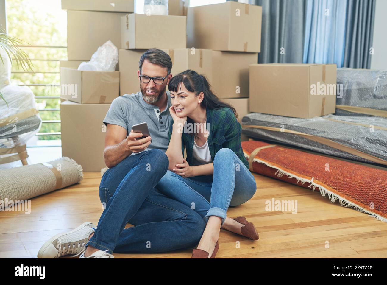 Making it a happy appy move. a husband and wife using a mobile phone ...