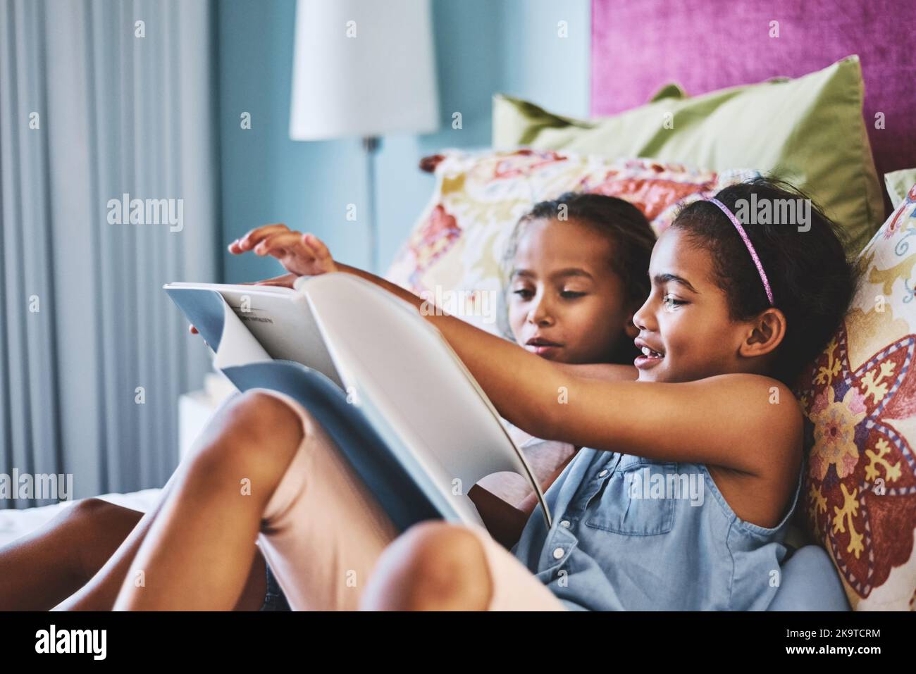 Turning the pages. two cheerful little girls reading a storybook ...