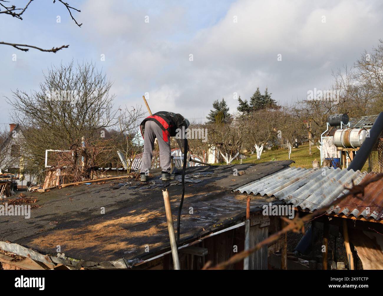 Workers disassemble and demolish an old wooden hut by hand Stock Photo ...