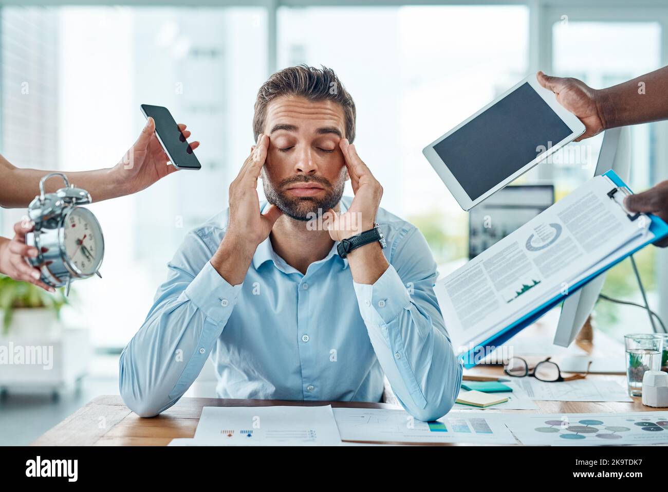 Drowning in the demands of a busy workday. Portrait of a young businessman looking stressed out ...