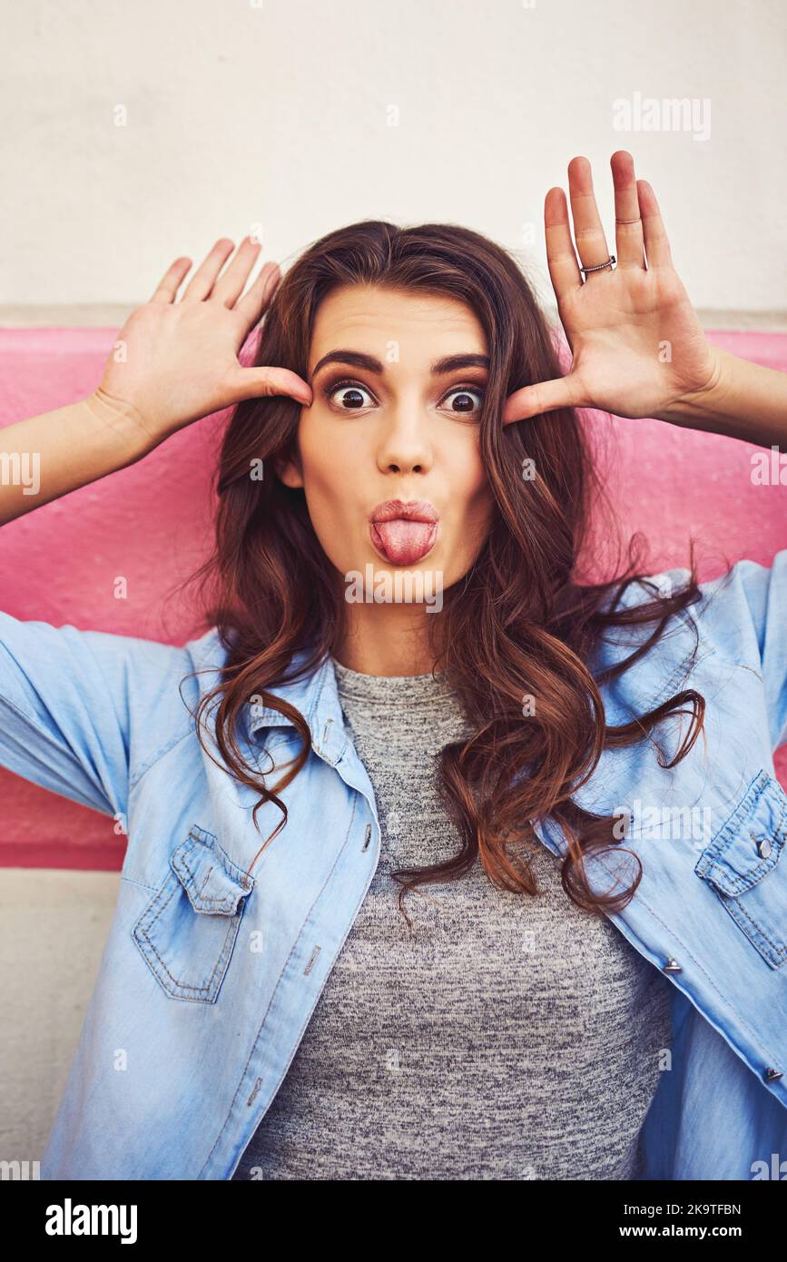 Making funny faces and loving it. Portrait of a beautiful young woman ...