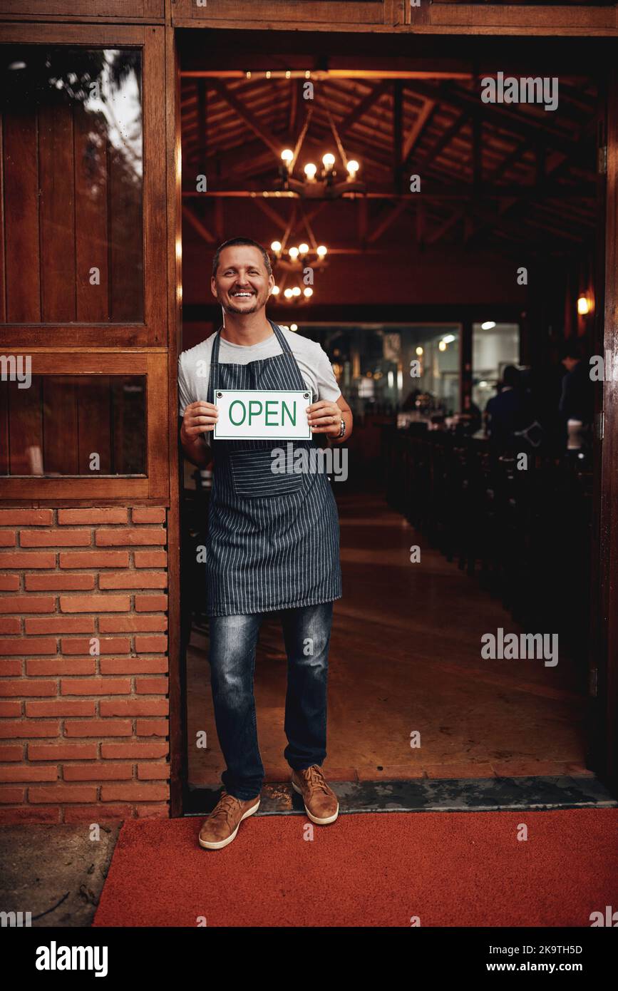 Take a step inside. Portrait of a cheerful middle aged business owner ...