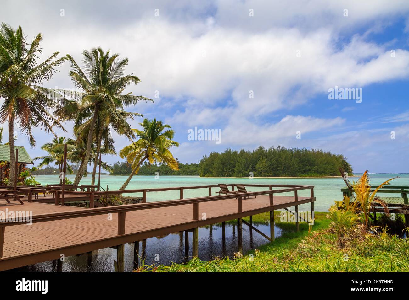 A wooden deck with sun loungers on tropical Muri Beach, Rarotonga, Cook ...