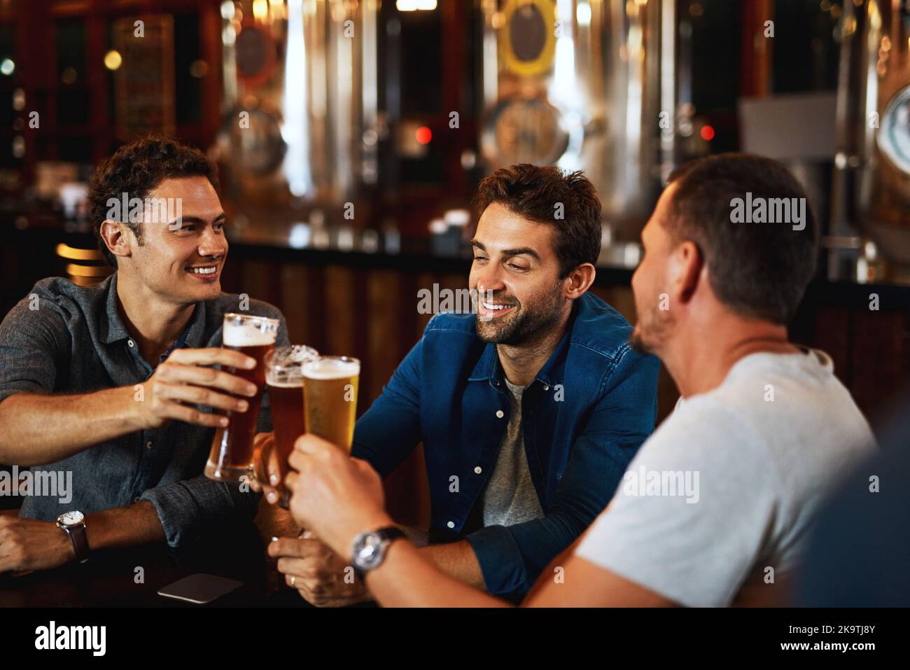 This round is on me. a group of young friends seated at a table ...