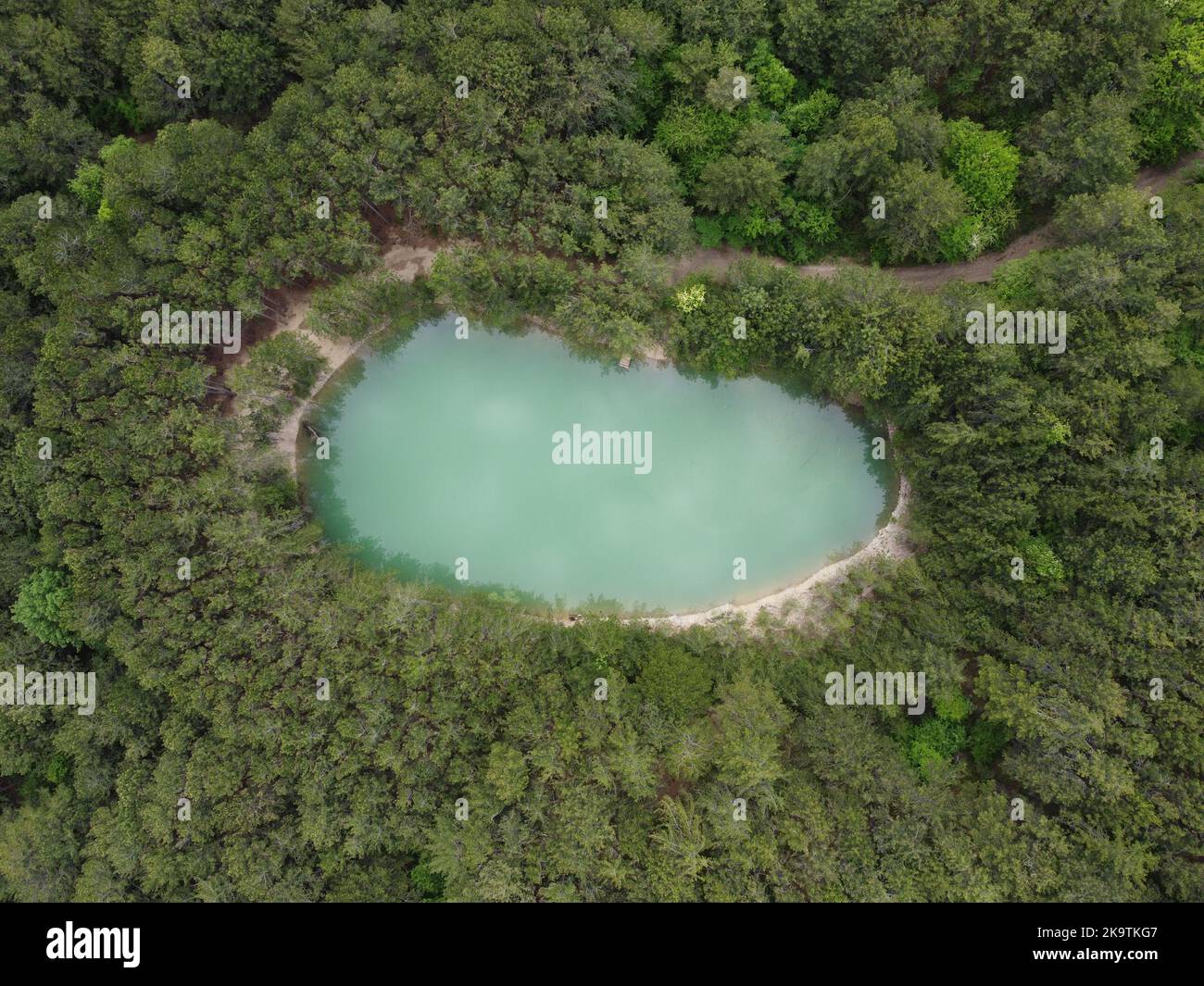 Aerial lake in forest. Top down view aerial flight over small lake of ...