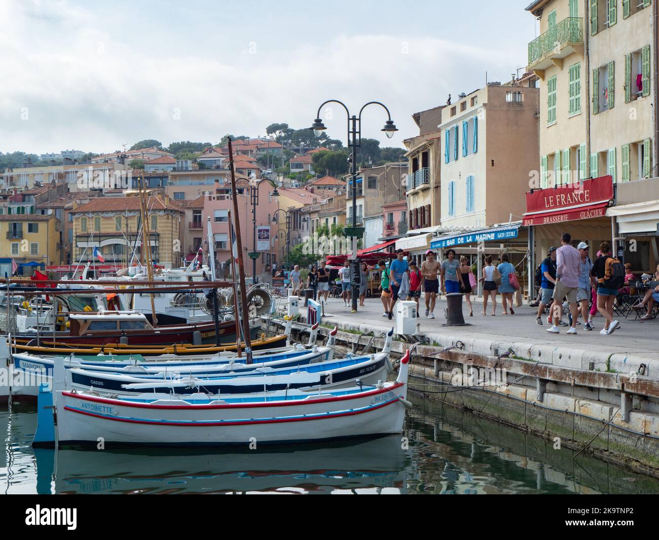 Cassis, France - May 18th 2022: Old fishing boats moored at the walking ...