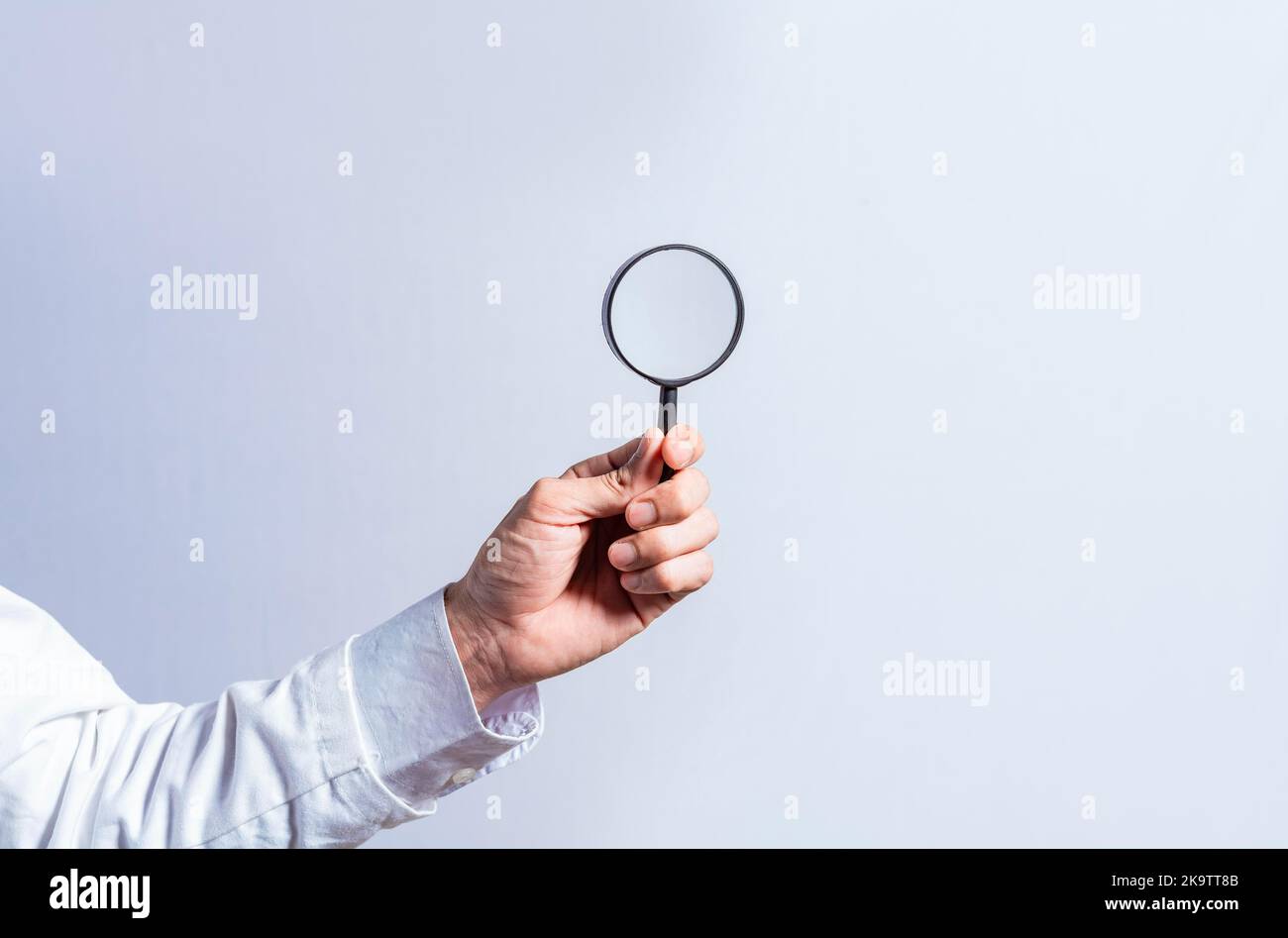 Man hand holding magnifying glass on white background. Hand holding ...