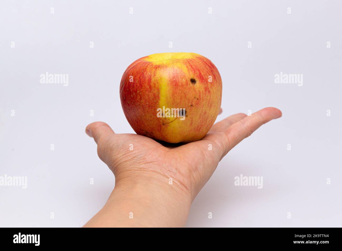 Red rotten apple concept eaten by worms Stock Photo - Alamy