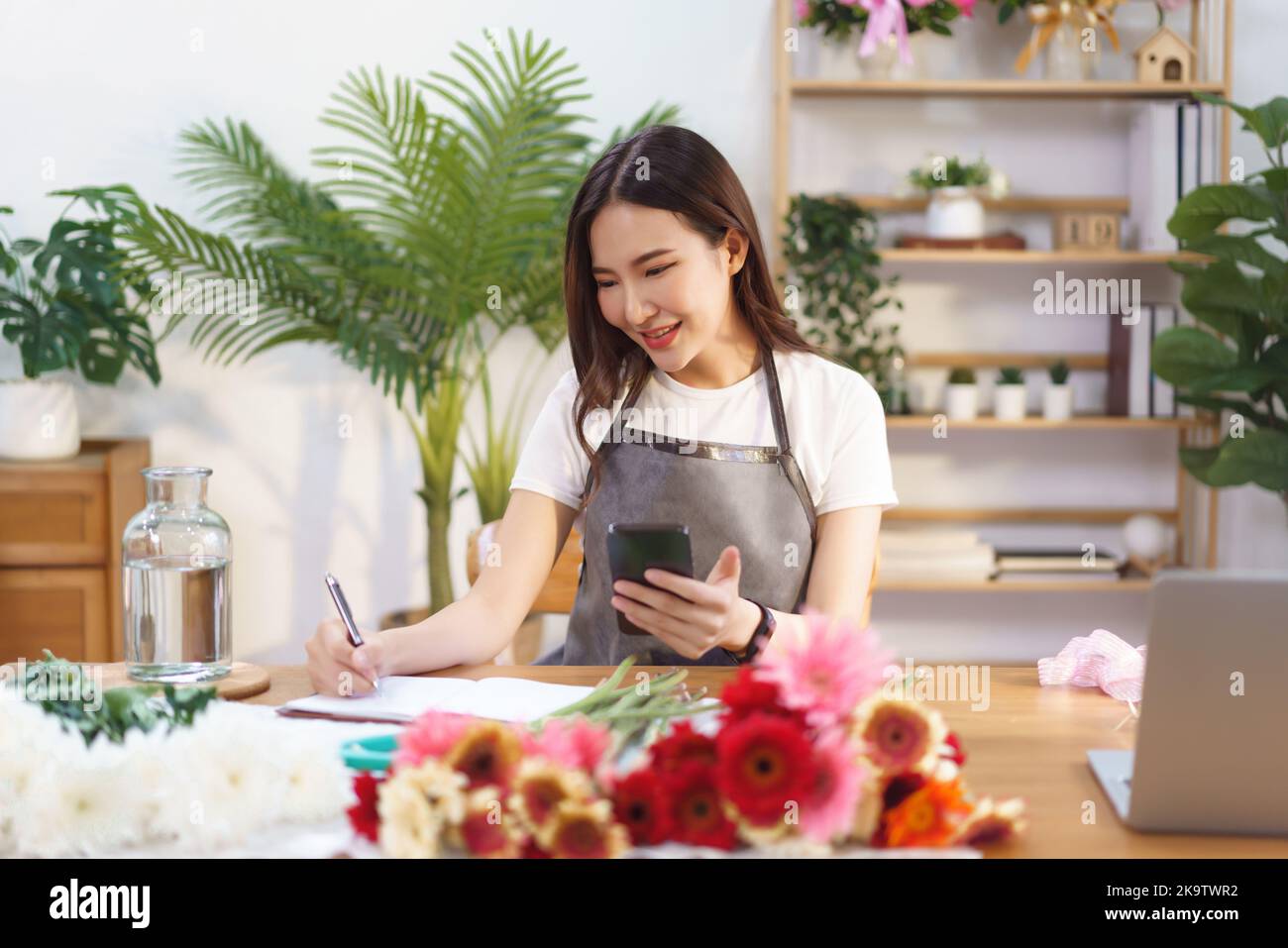 Flower shop concept, Female florist checking flower orders on ...