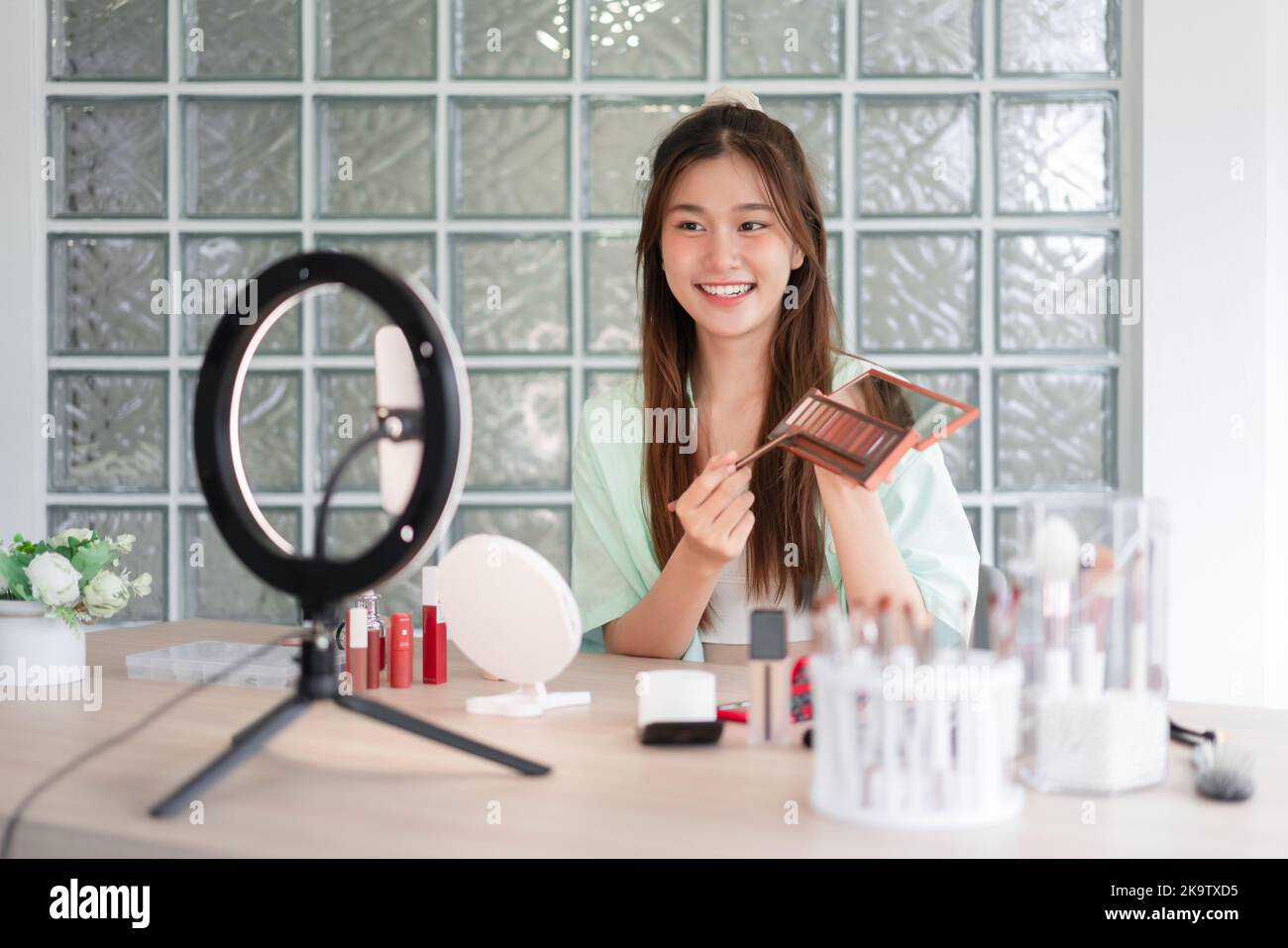 Beauty influencer concept, Young woman apply eyeshadow to present ...