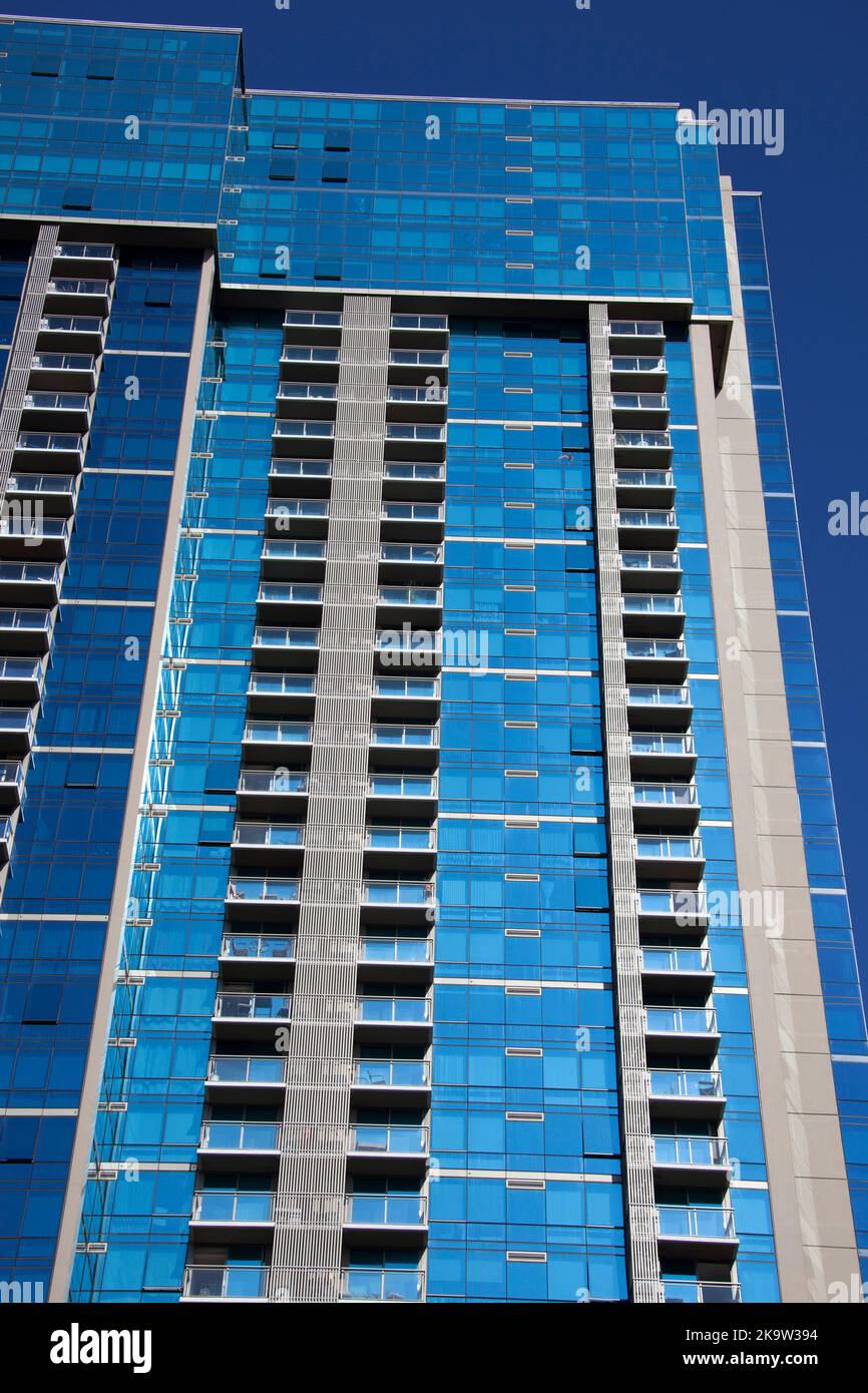 The view of modern glass covered blue color residential building in ...