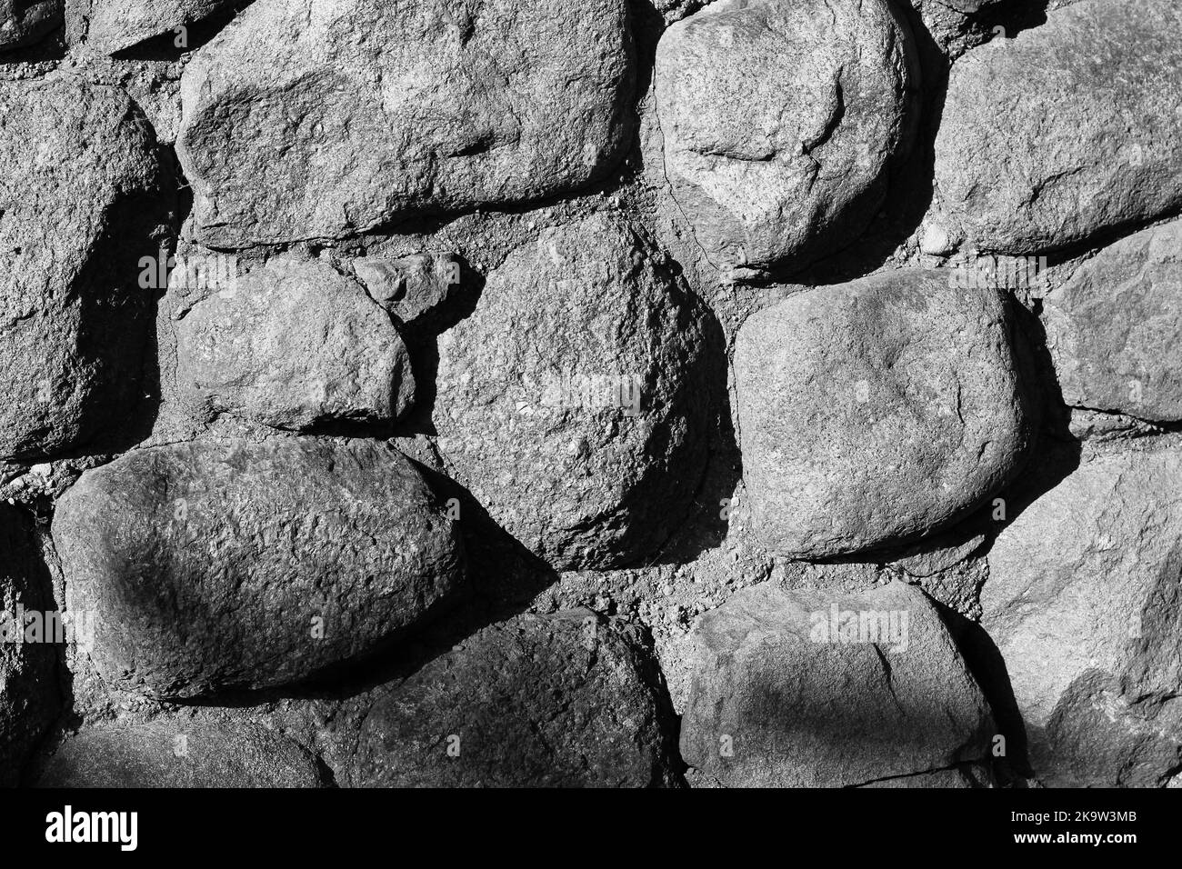 Vintage stone wall with a random pattern in a black and white ...