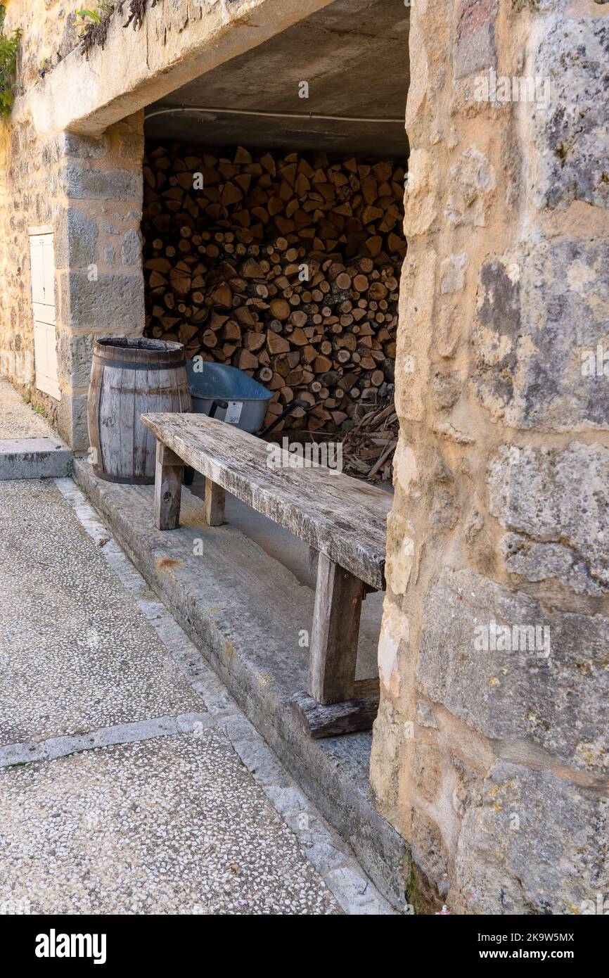 n old wooden barrel, hand made bench and wooden fire logs under a stone ...