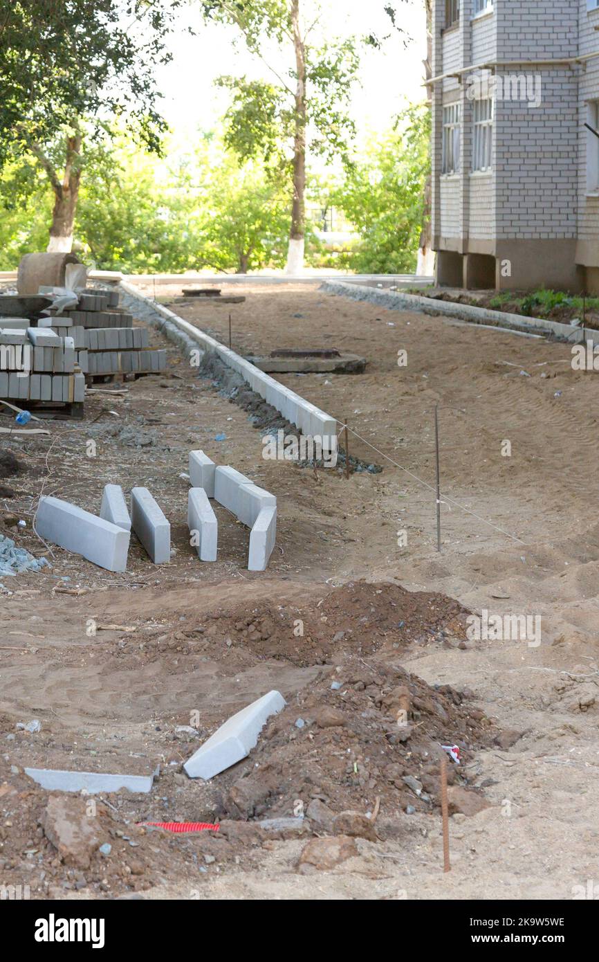 Beginning pavement construction installation of curb stone on sand ...