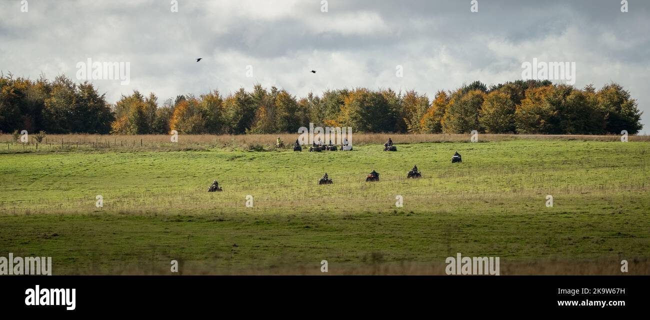 large group of quad bikers on a cross-country adventure, cloudy summer ...
