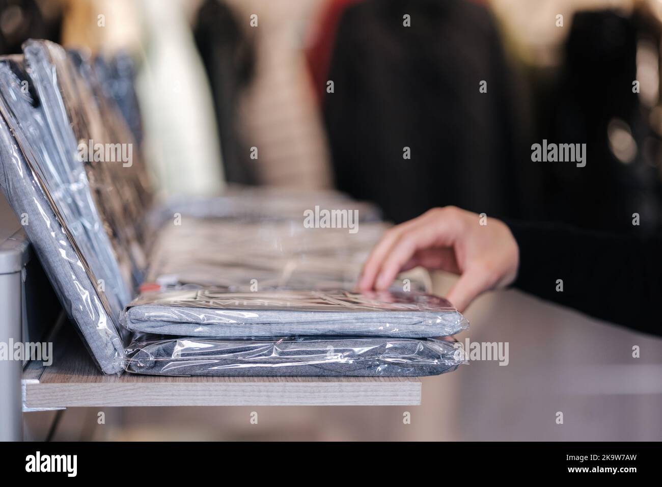 Close-up of human hand take goods from the shelf in clothes store Stock ...