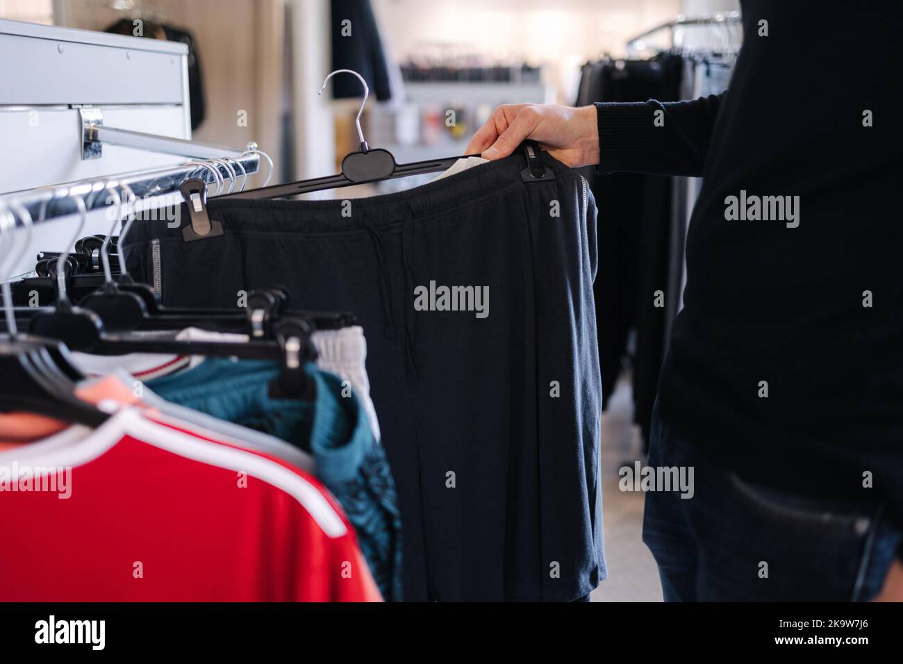 Close-up of human hand take clothes to try on. Male hand take pajamas ...