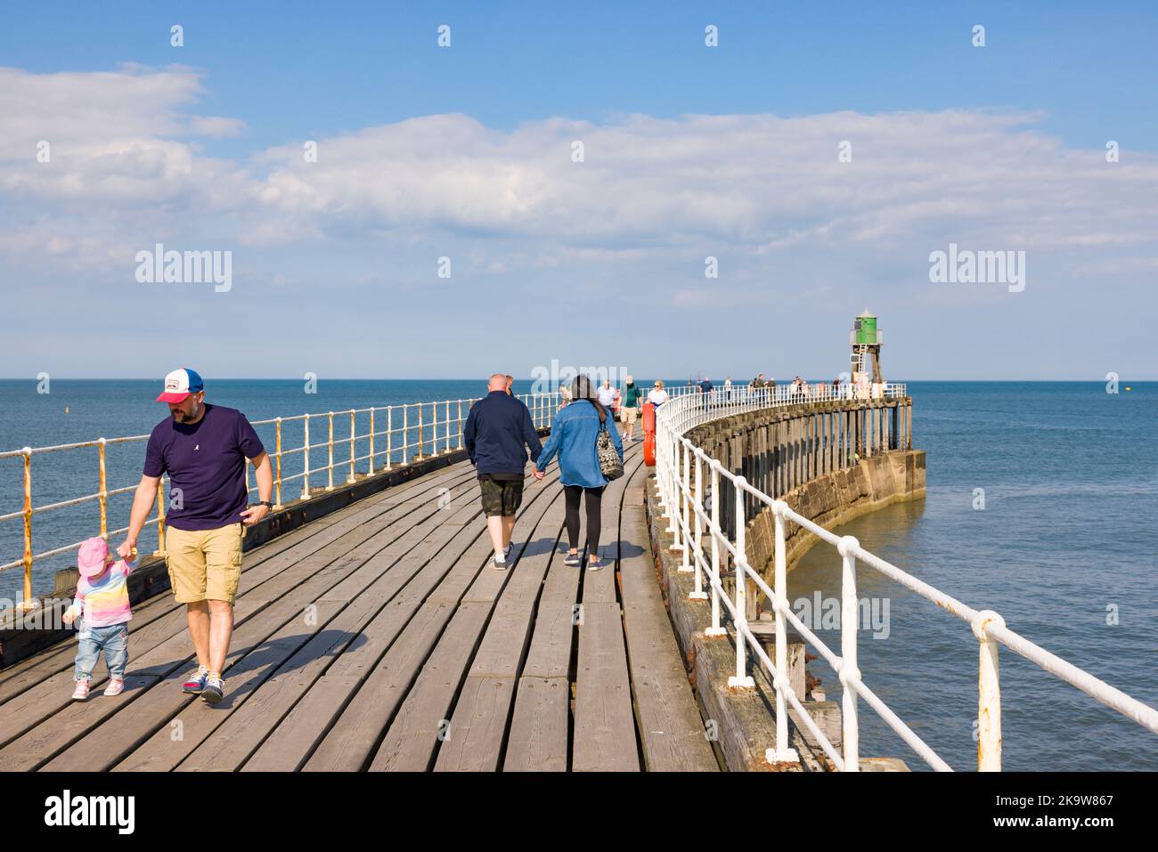 WHITBY, UK - September 21, 2022. Man with young child, tourists walking ...